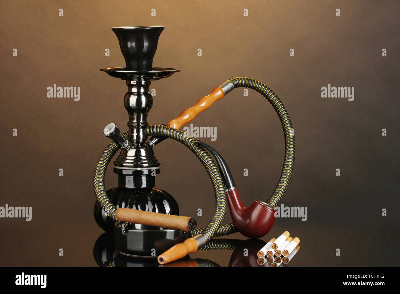 Smoking tools - a hookah, cigar, cigarette and pipe on brown background ...