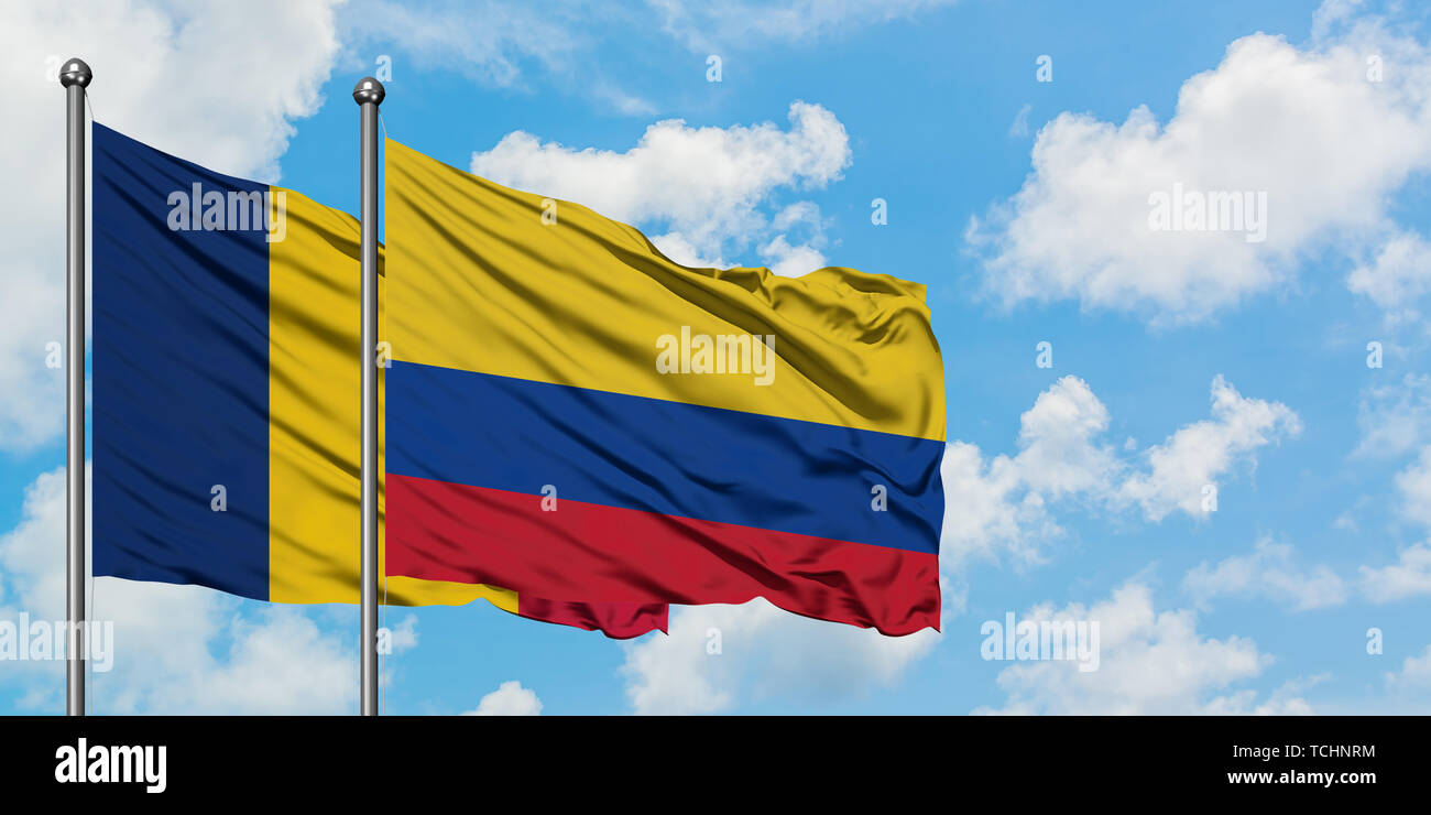 Chad and Colombia flag waving in the wind against white cloudy blue sky ...