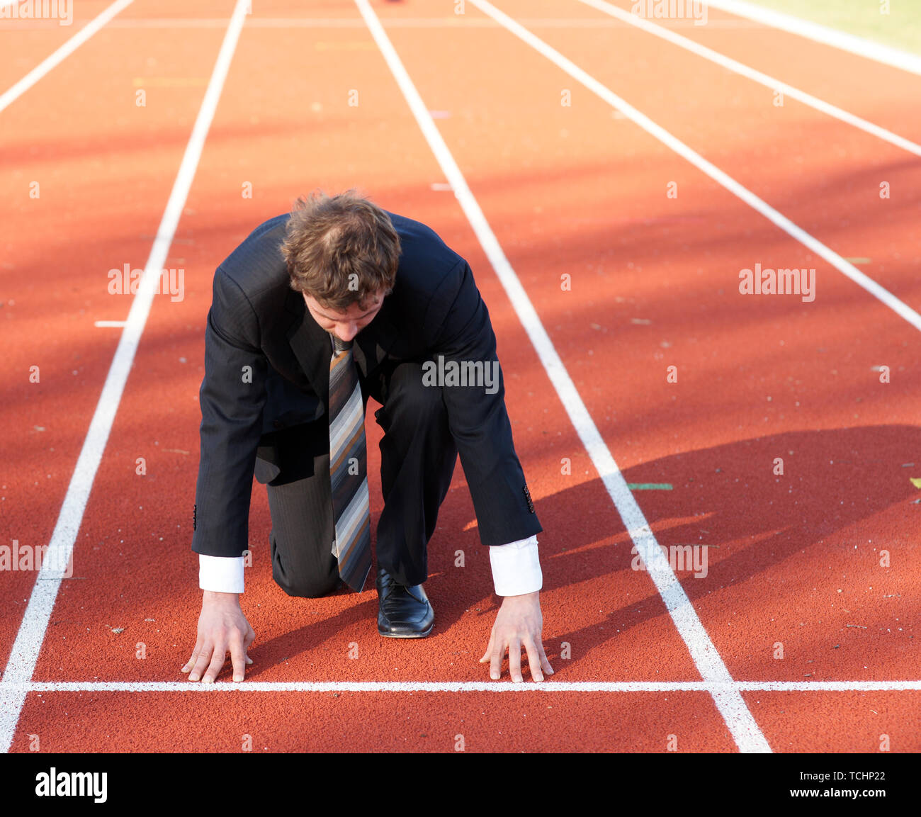 Business man waiting for start signal to run on the competition running ...