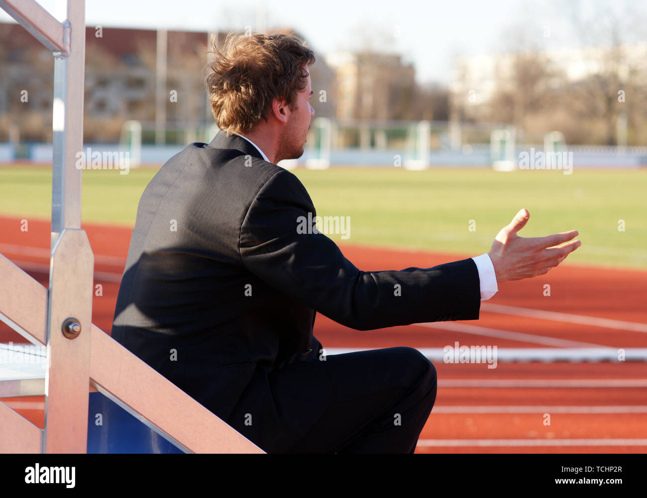 Spectator Trainer Coach sitting in Stadium in Front of Running Track ...