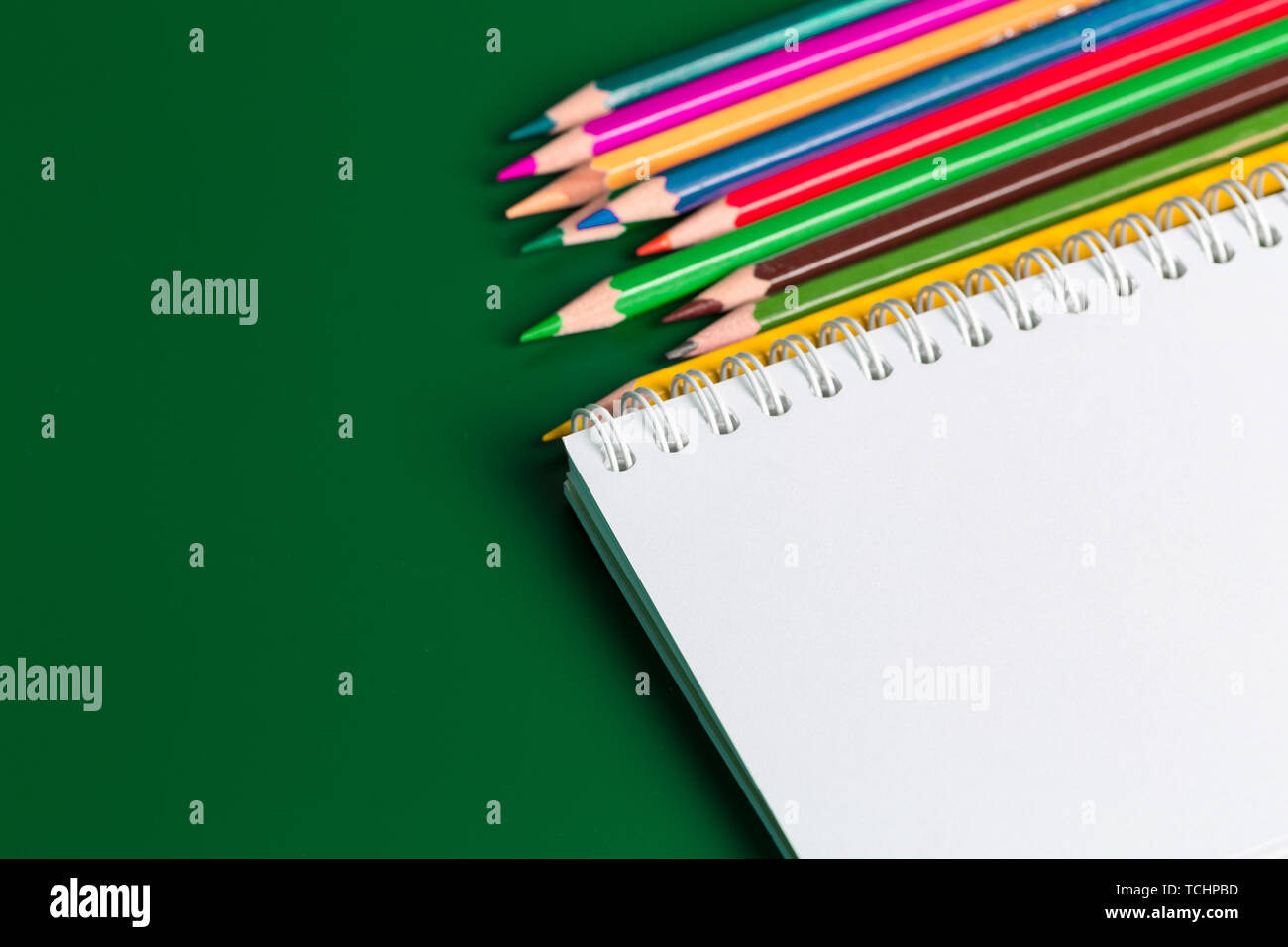 Note book and colored pencils Stock Photo - Alamy