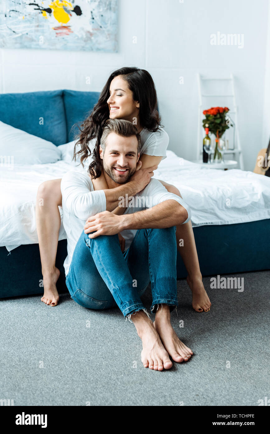 beautiful woman hugging happy barefoot boyfriend in bedroom Stock Photo - Alamy