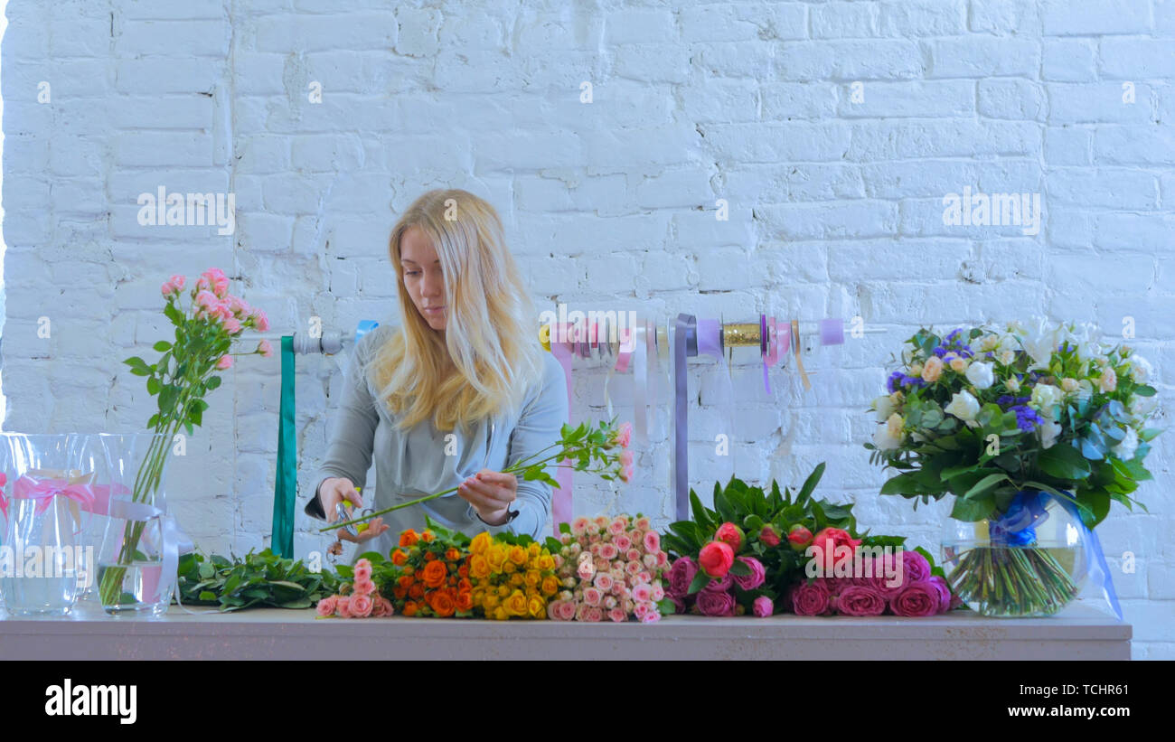 Professional florist cutting flower stems at flower store Stock Photo ...