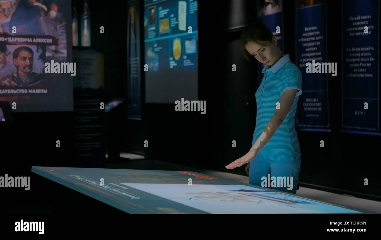 Woman using interactive display at modern history museum Stock Photo ...