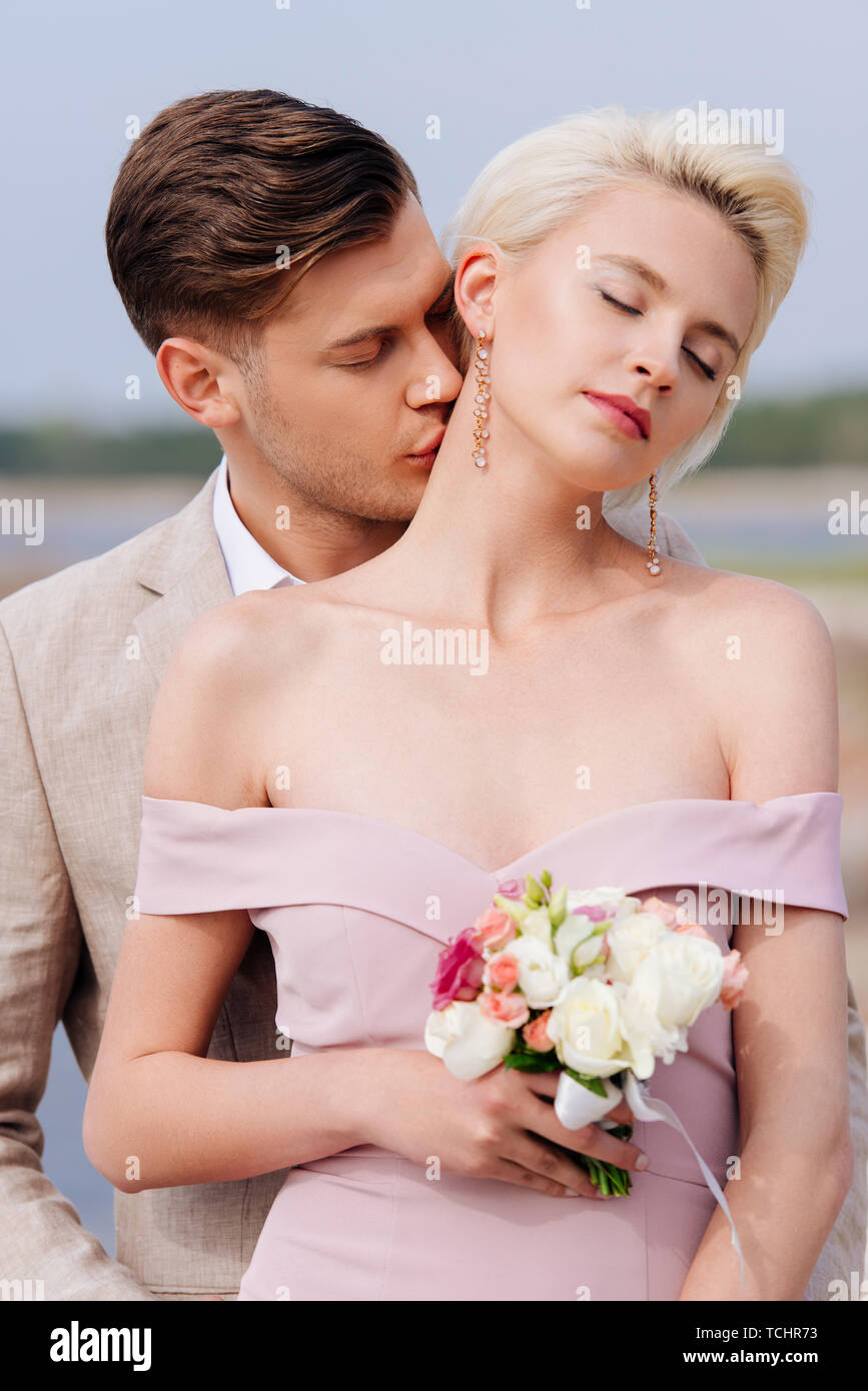 stylish bridegroom kissing bride in neck with closed eyes Stock Photo ...