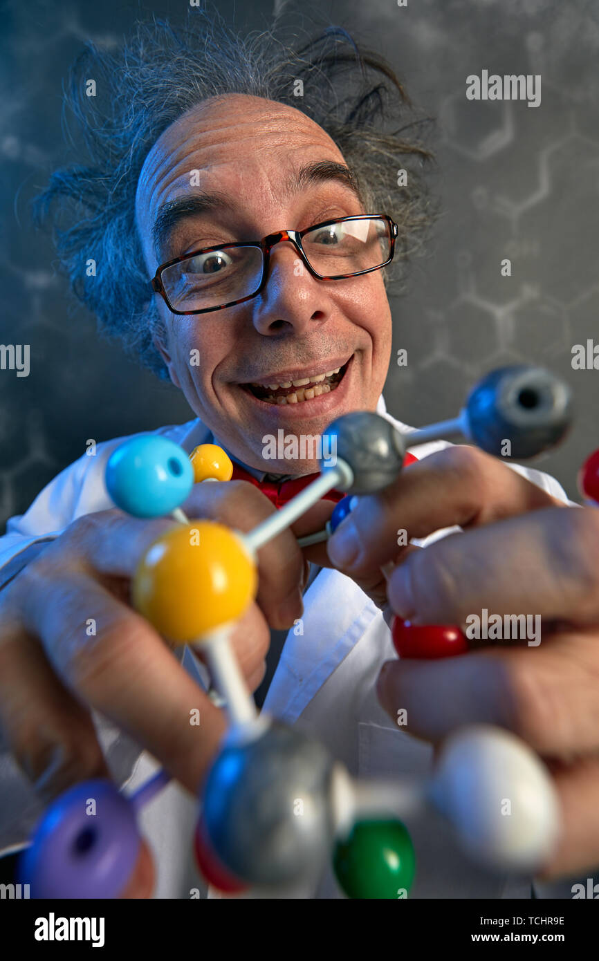 Funny scientist holding structure of model molecules with atoms in ...