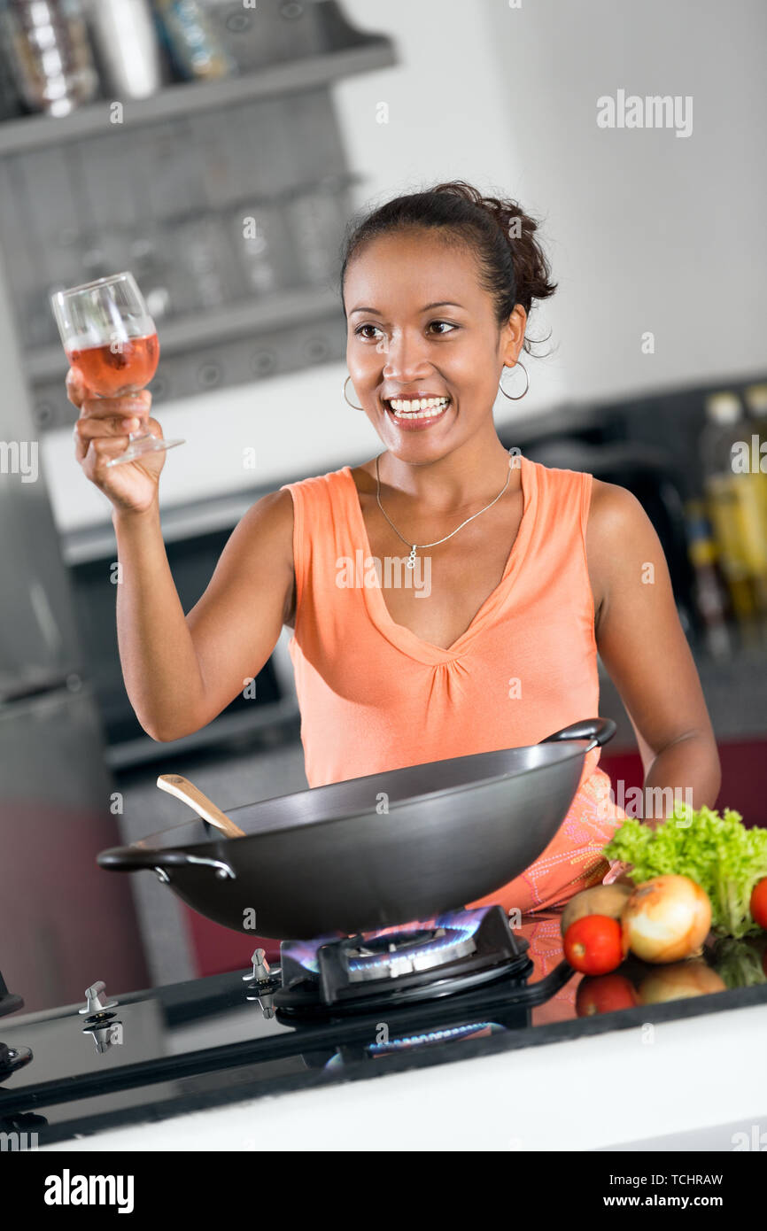 Young woman cooking for friends, she standing in kitchen and toast in ...