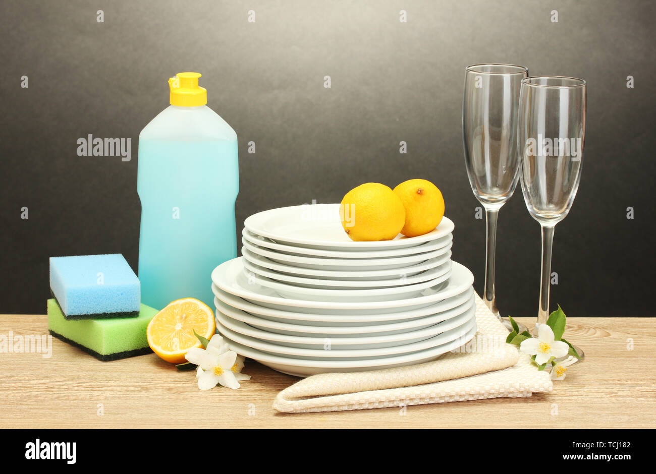 empty clean plates and glasses with dishwashing liquid, sponges and ...