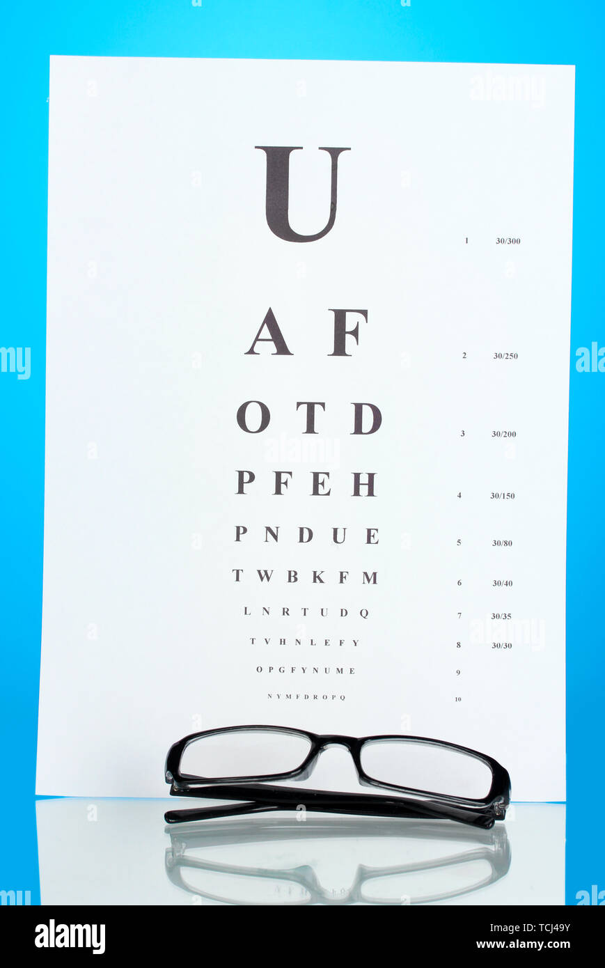 Eyesight test chart with glasses on blue background close-up Stock ...
