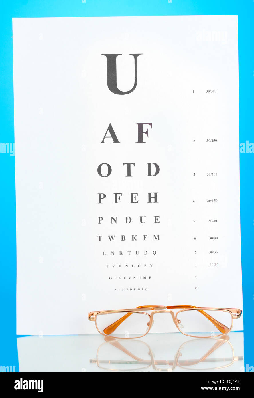 Eyesight test chart with glasses on blue background close-up Stock ...