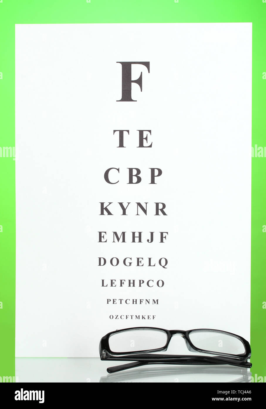 Eyesight test chart with glasses on green background close-up Stock ...