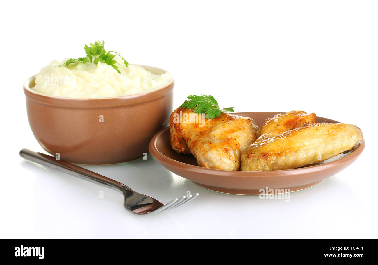 Mashed potato with parsley in the bowl and roasted chicken wings in the ...