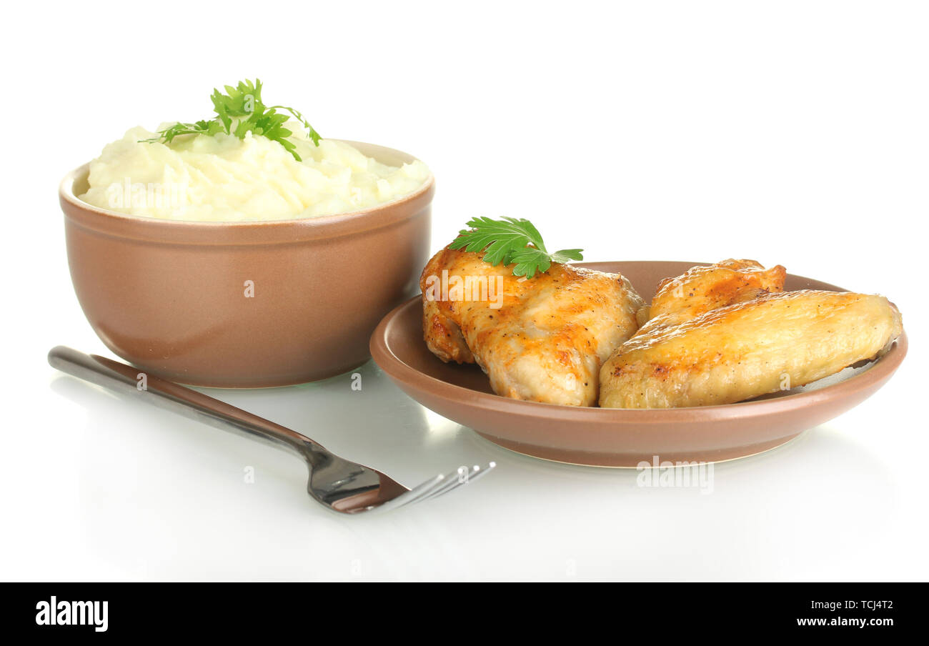 Mashed potato with parsley in the bowl and roasted chicken wings in the ...