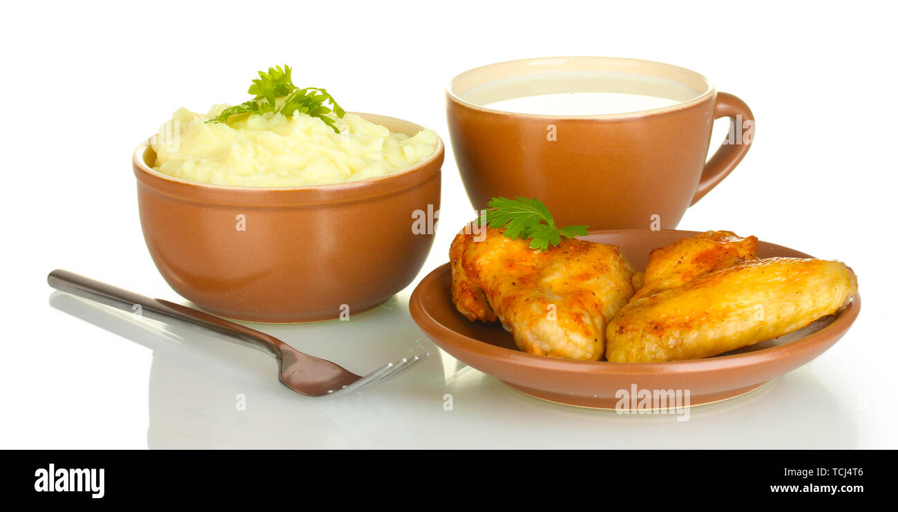 Mashed potato with parsley in the bowl and roasted chicken wings in the ...