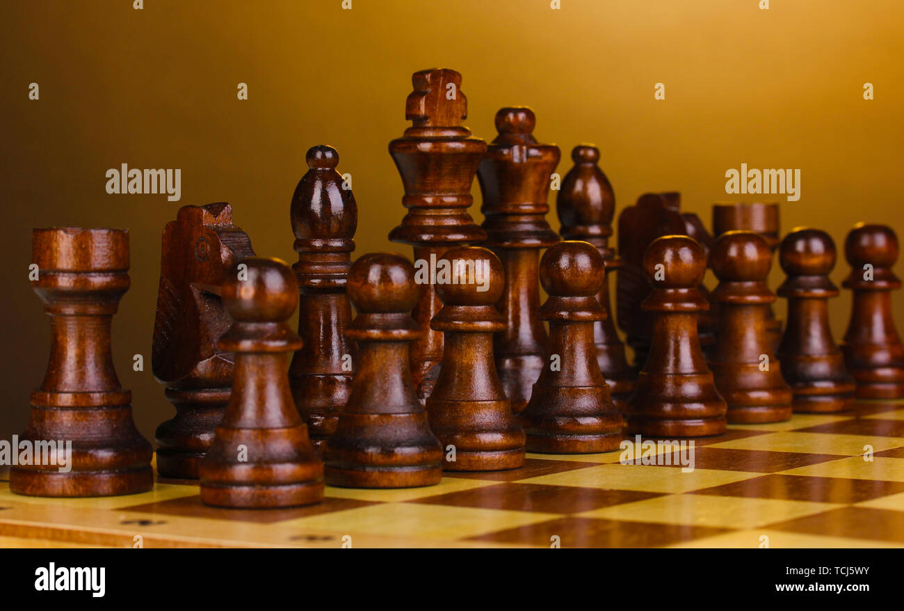 Chess board with chess pieces on brown background Stock Photo - Alamy