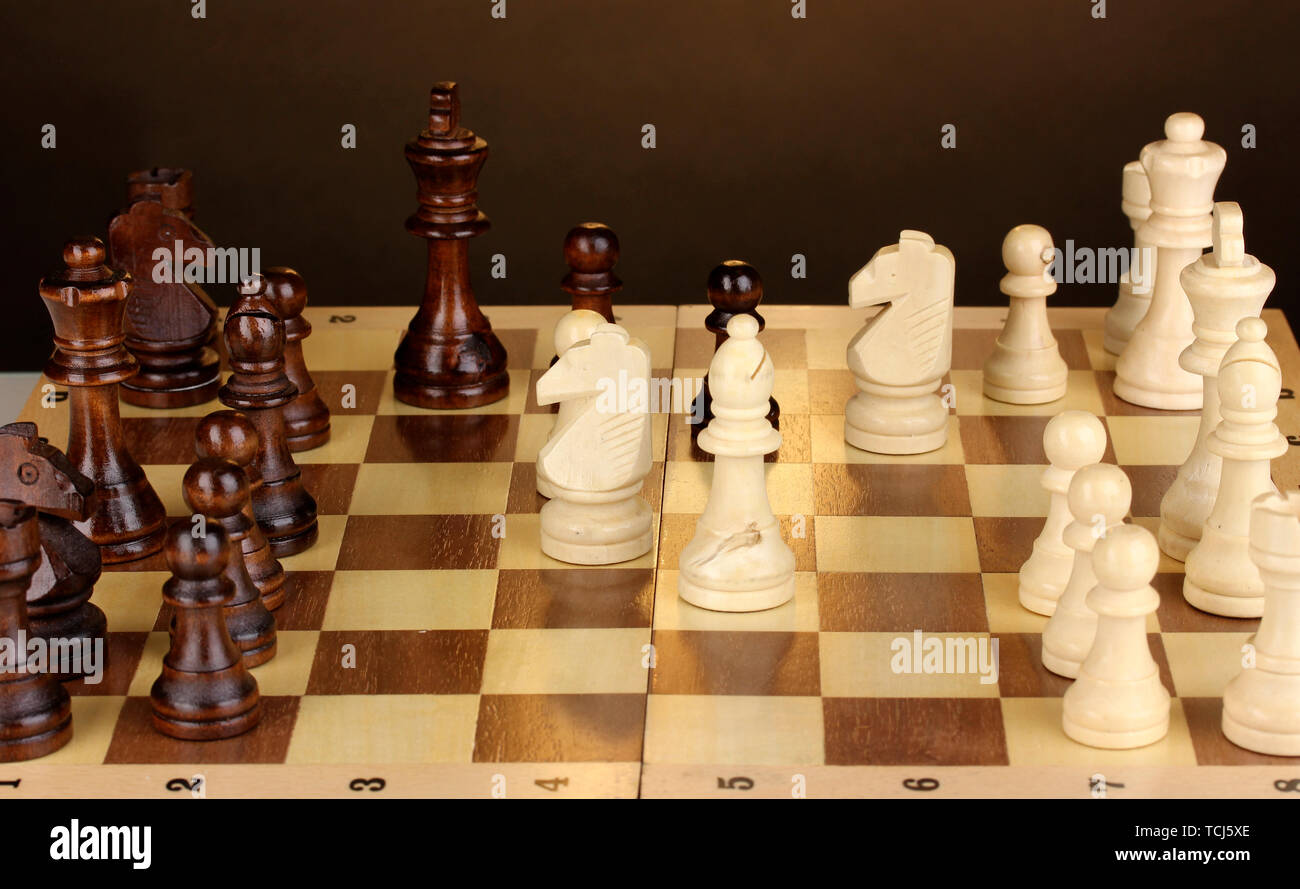 Chess board with chess pieces on brown background Stock Photo - Alamy