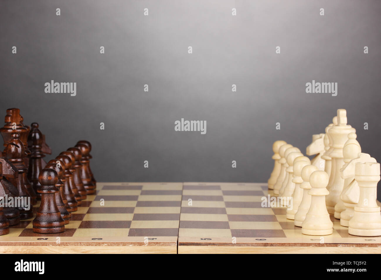 Chess board with chess pieces on grey background Stock Photo - Alamy
