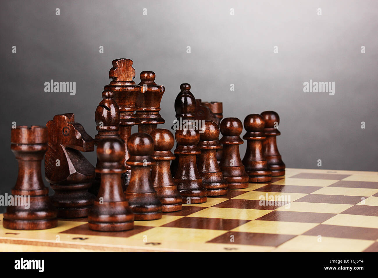 Chess board with chess pieces on grey background Stock Photo - Alamy