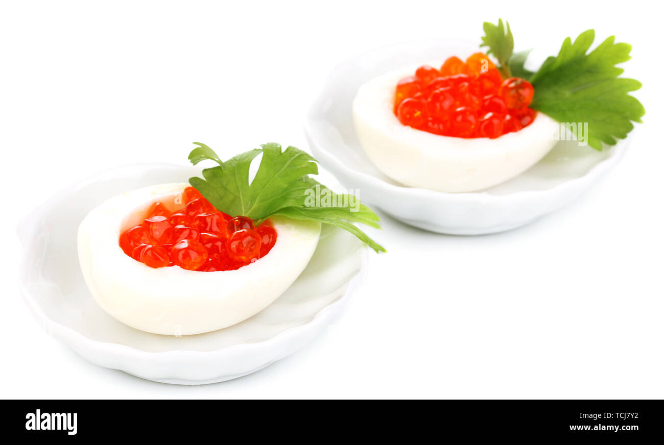 Red caviar in eggs on little white saucers isolated on white Stock ...