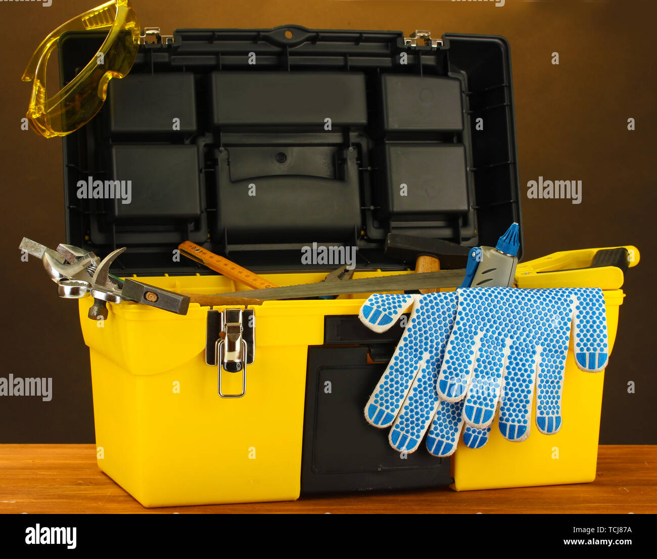 Open yellow tool box with tools on brown background close-up Stock ...
