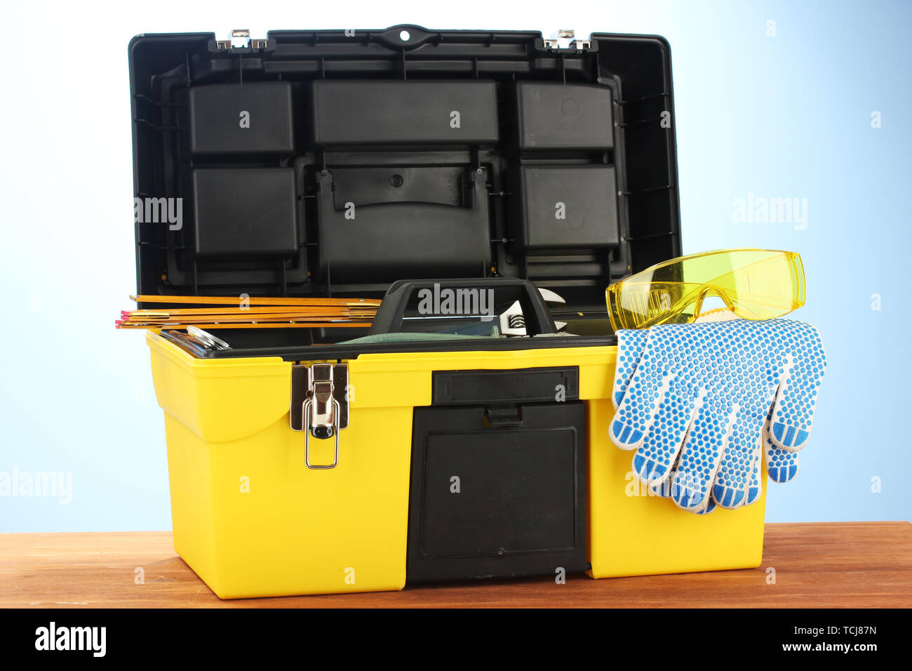 Open yellow tool box with tools on blue background close-up Stock Photo ...