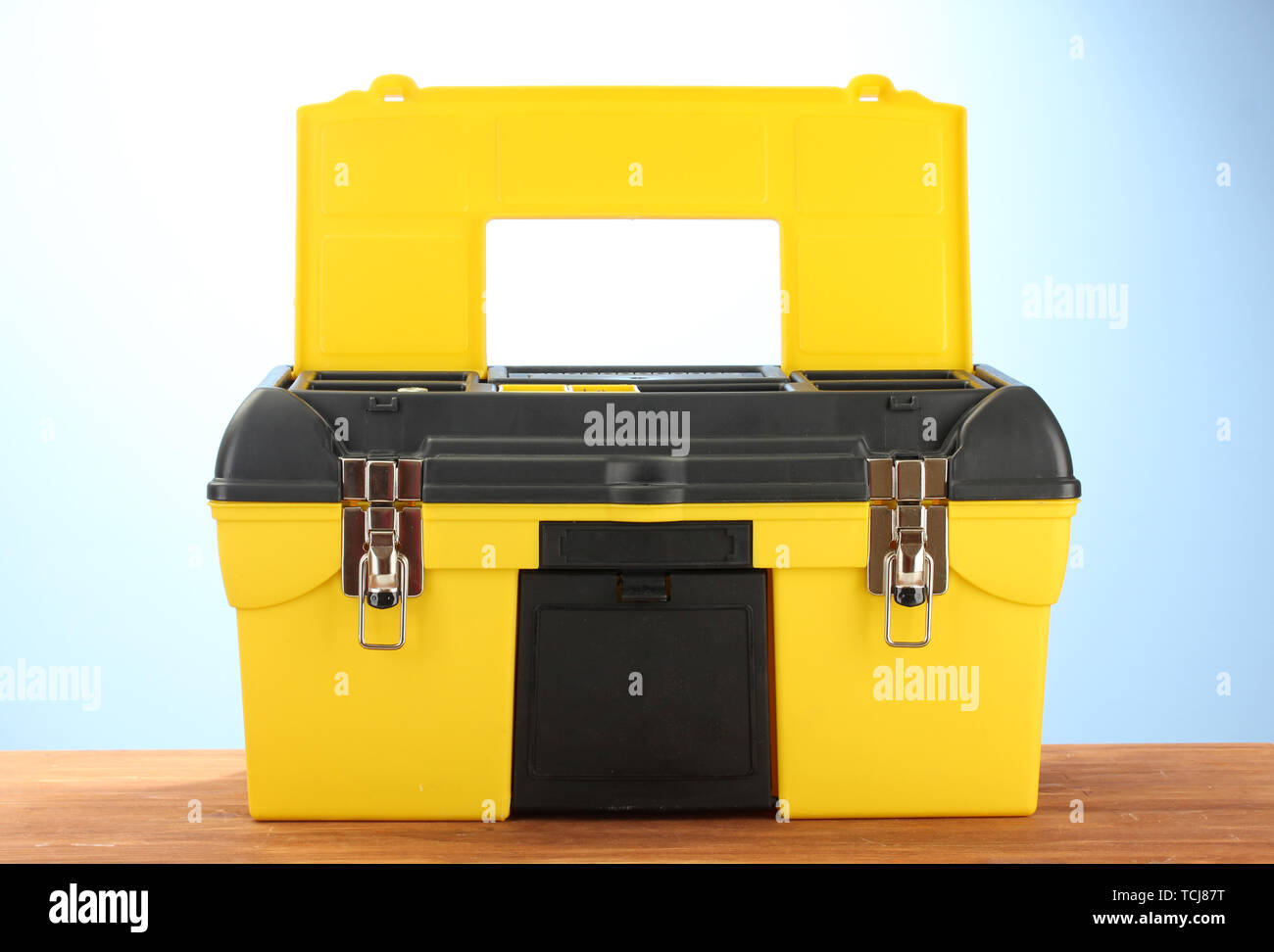 Open yellow tool box on blue background close-up Stock Photo - Alamy