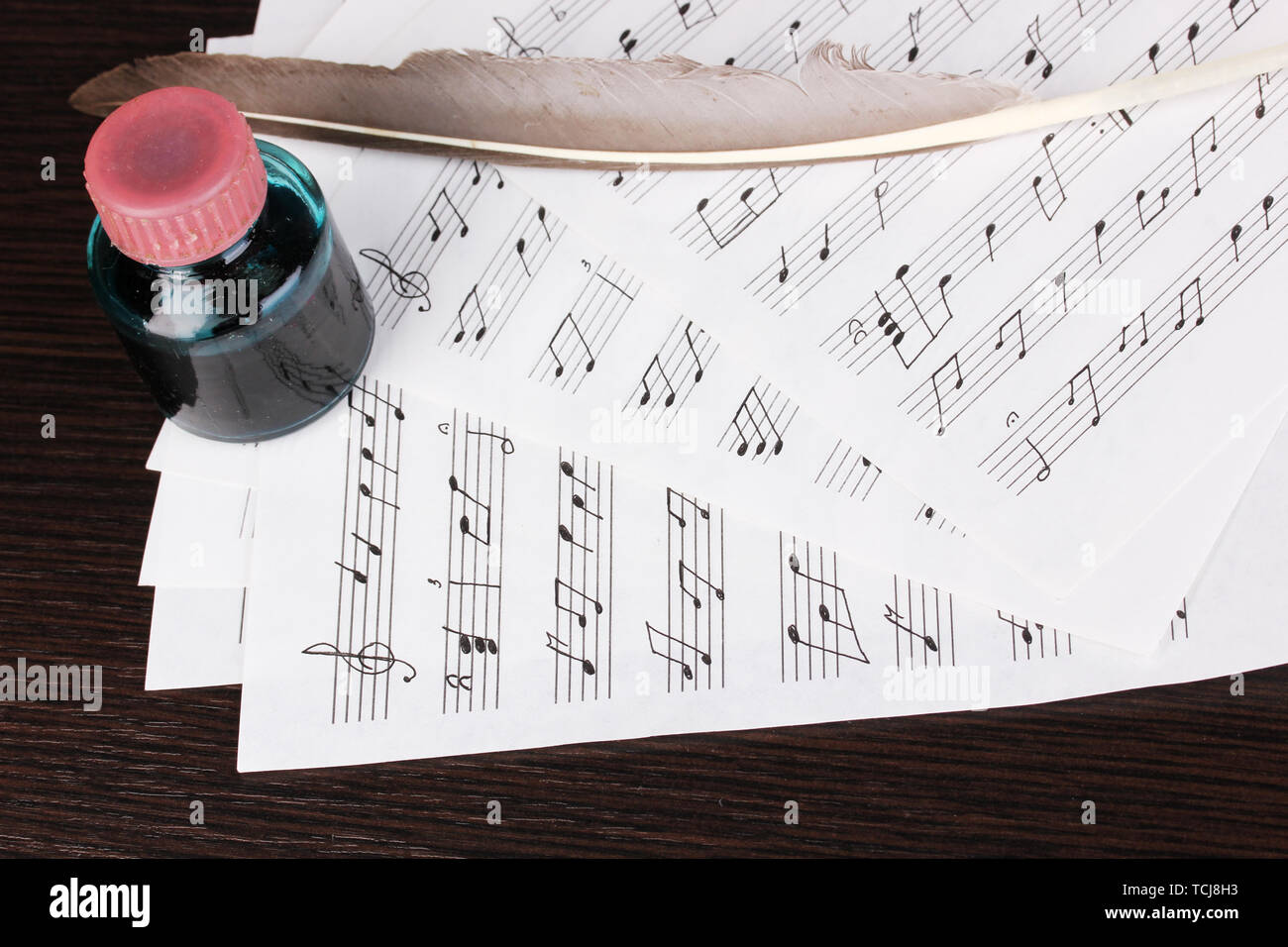 Musical notes and feather on wooden table Stock Photo - Alamy