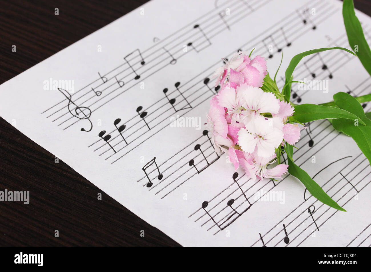 Musical notes and flower on wooden table Stock Photo - Alamy