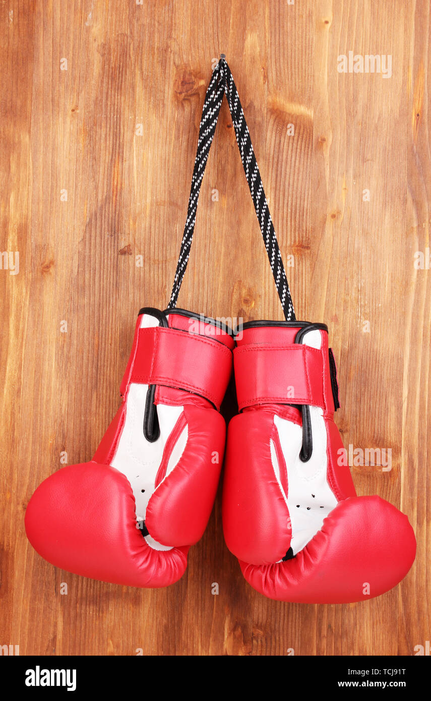 Red boxing gloves hanging on wooden background Stock Photo - Alamy