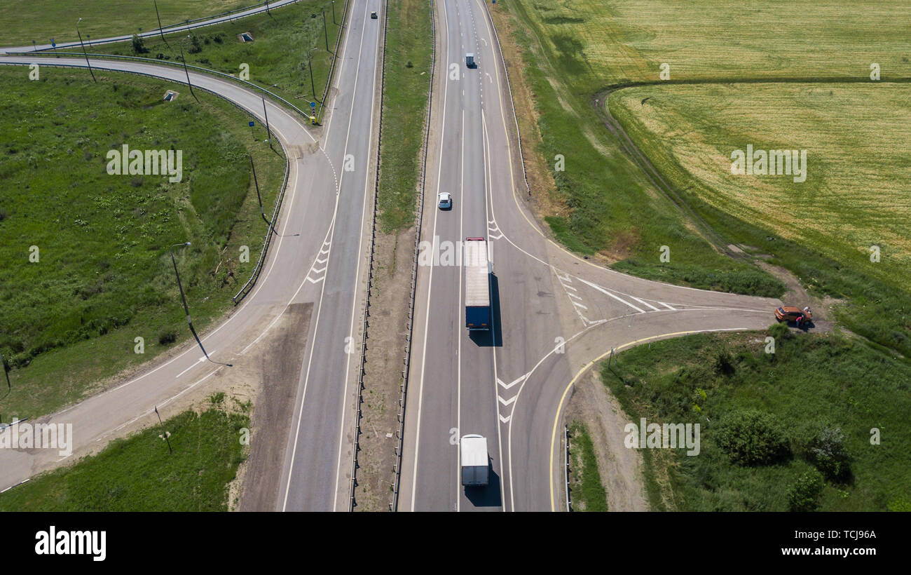 Aerial view of modern highway road intersection on rural landscape ...