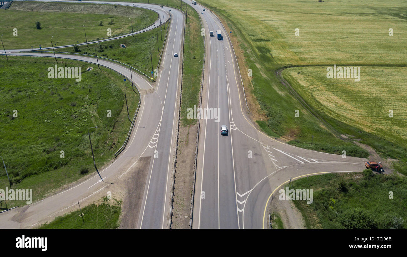 Aerial view of modern highway road intersection on rural landscape ...