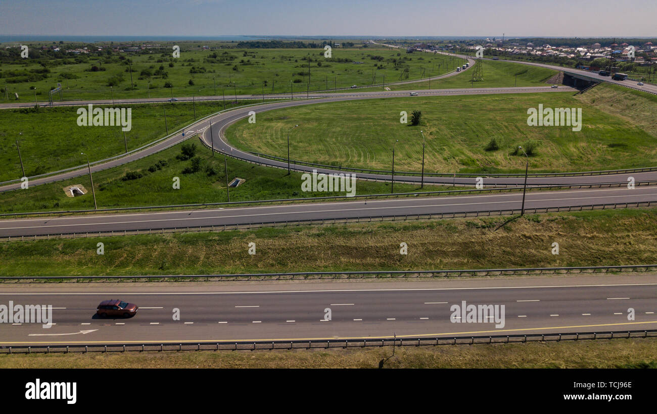 Aerial view of modern highway road intersection on rural landscape ...
