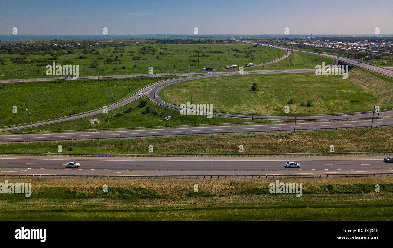 Aerial view of modern highway road intersection on rural landscape ...