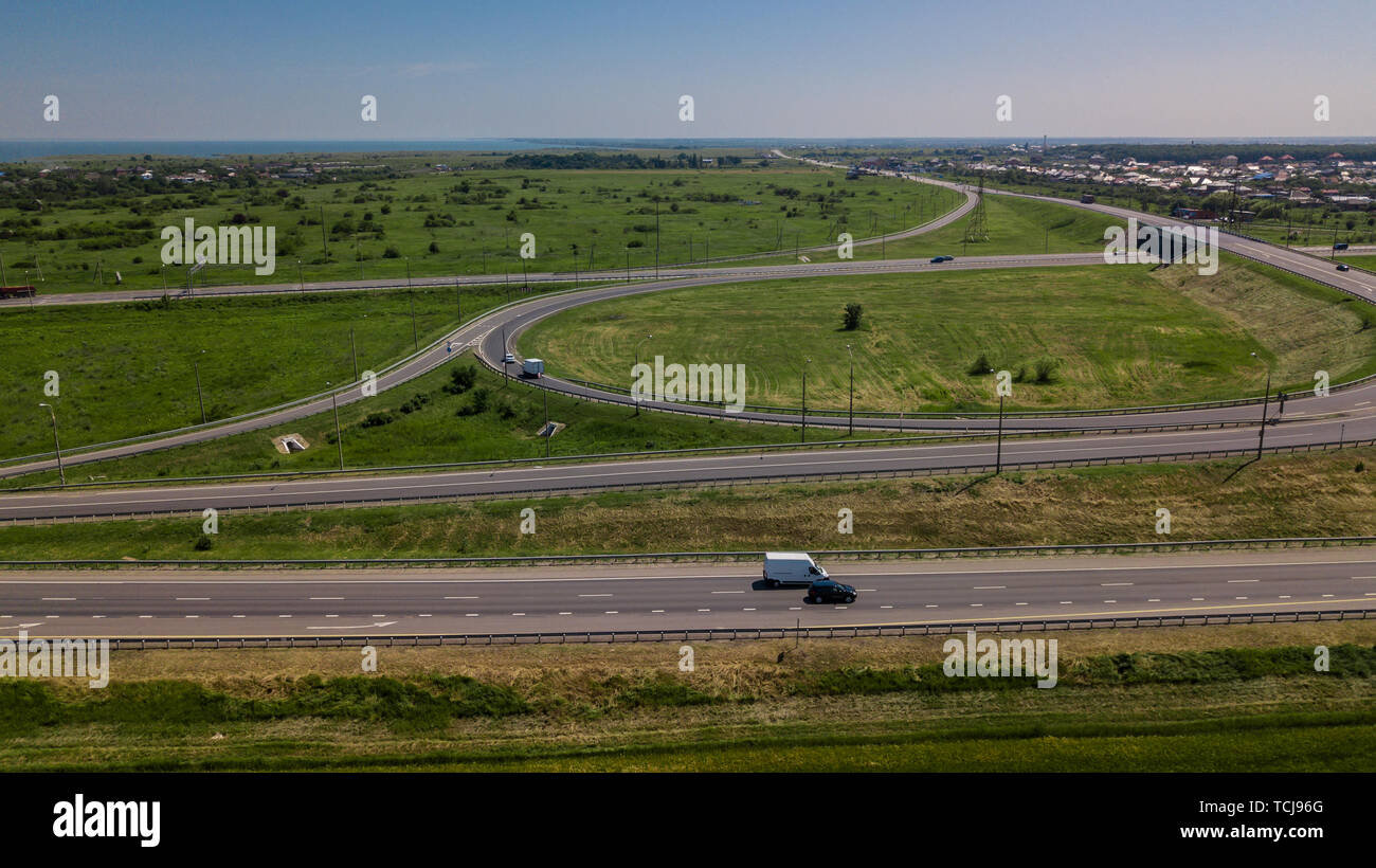 Aerial view of modern highway road intersection on rural landscape ...