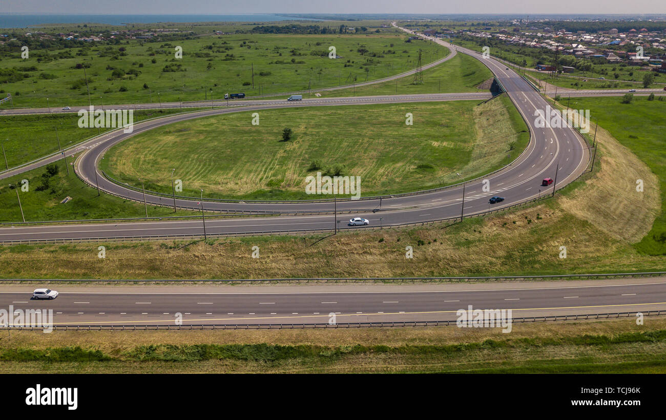 Aerial view of modern highway road intersection on rural landscape ...