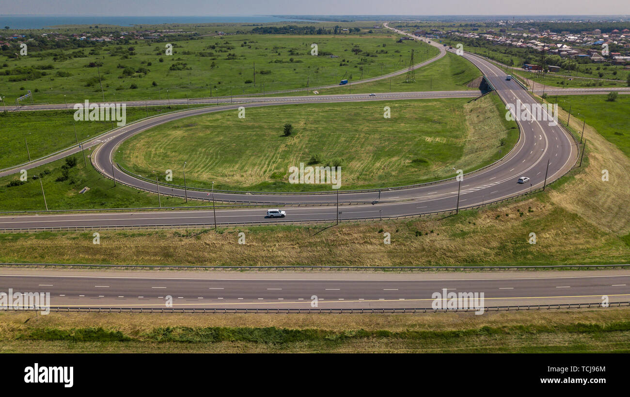 Aerial view of modern highway road intersection on rural landscape ...