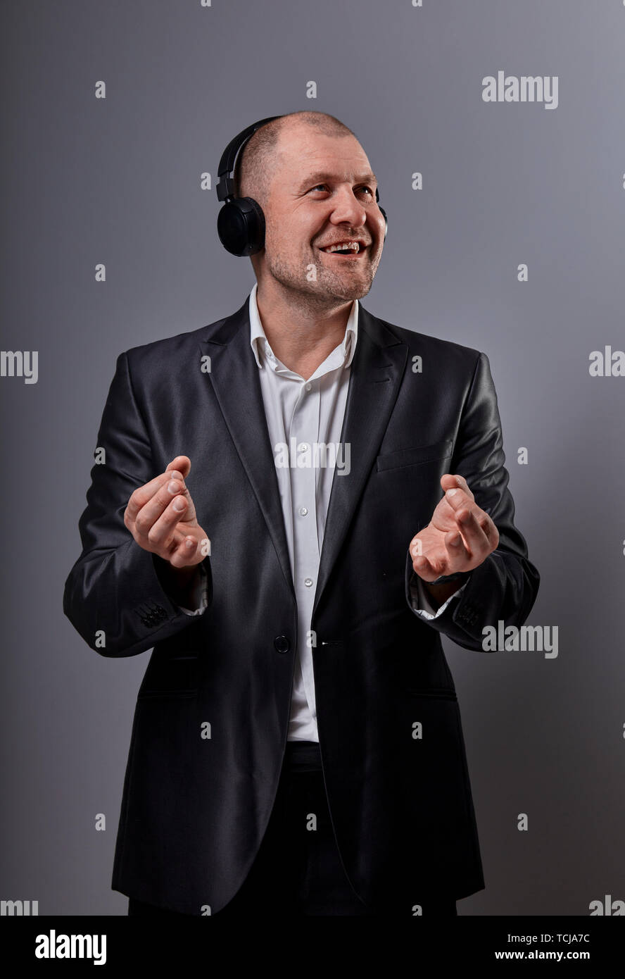 Happy smiling dancing bald man listening the music in wireless ...