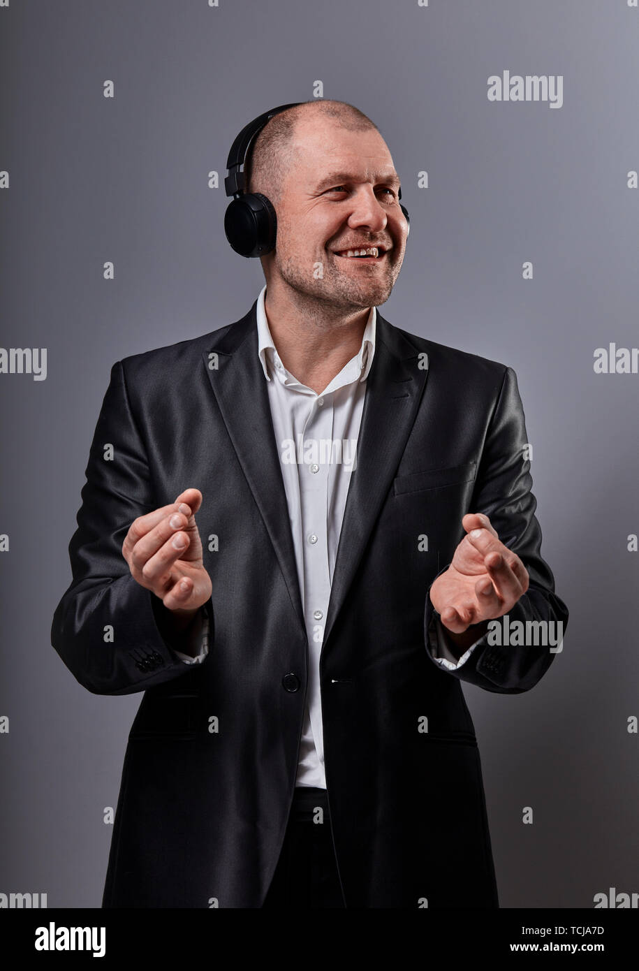 Happy smiling emotional dancing and singing bald man listening the ...