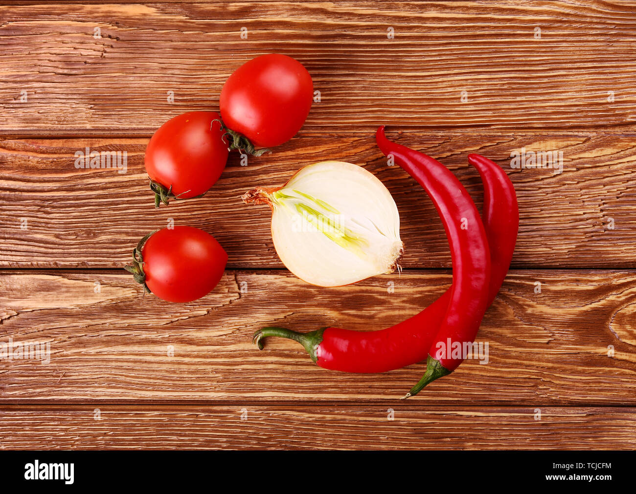 Red hot cherry and chili peppers over white wooden background onion ...
