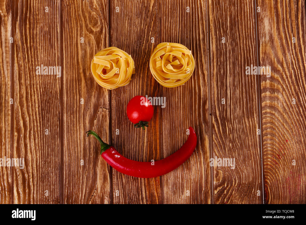 pasta on wooden background with tomato and pepper top view? smiley face ...