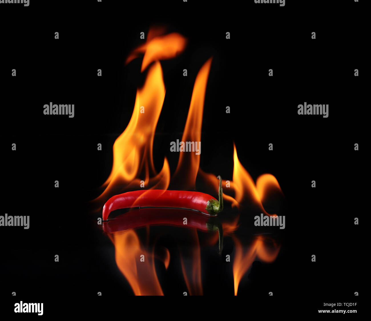 Hot pepper with flame on black background Stock Photo - Alamy