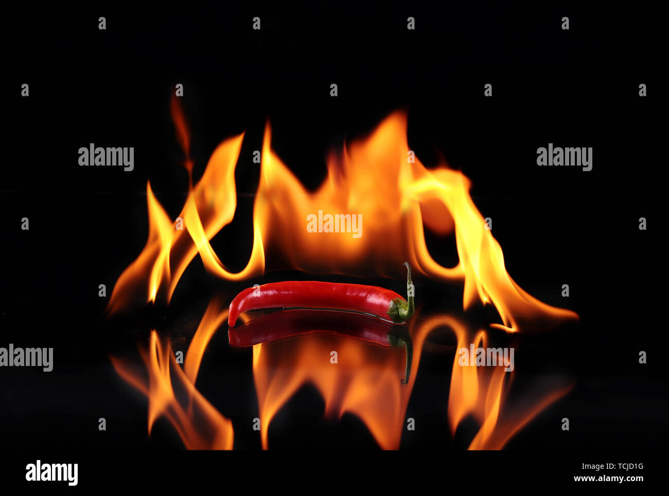Hot pepper with flame on black background Stock Photo - Alamy