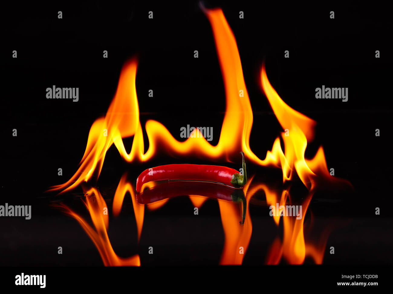 Hot pepper with flame on black background Stock Photo - Alamy