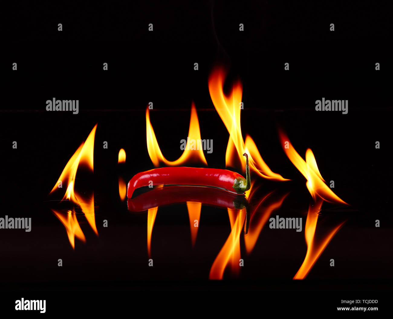 Hot pepper with flame on black background Stock Photo - Alamy