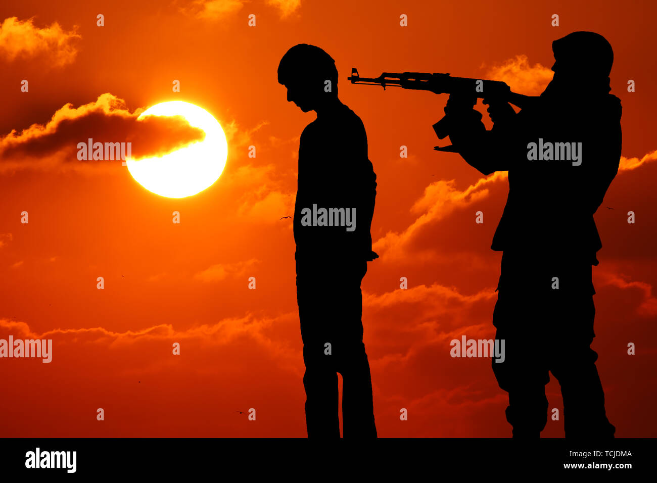 Silhouette of man with rifle pointed at victim's back Stock Photo - Alamy