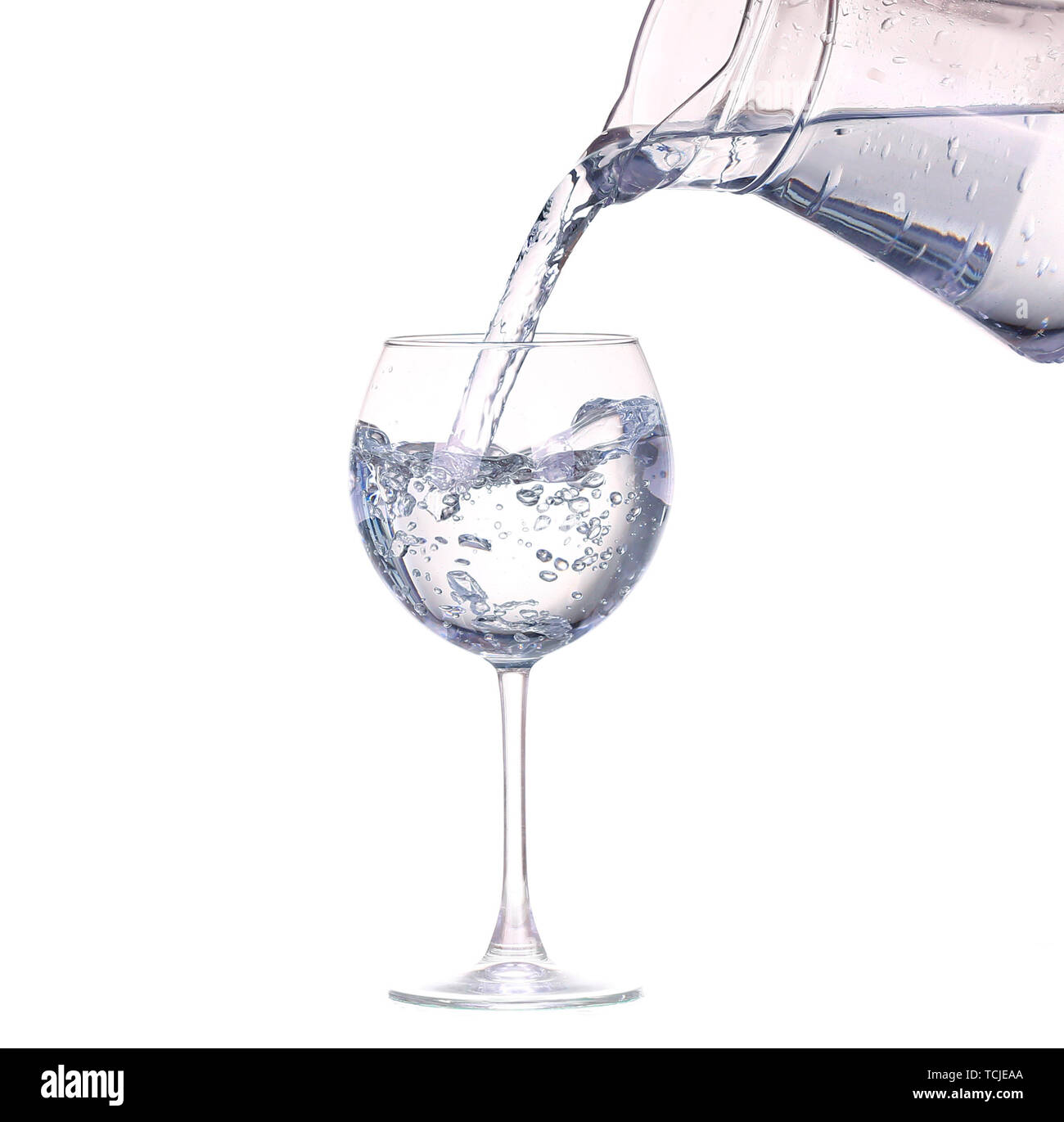 Pouring water from glass pitcher on white background Stock Photo - Alamy