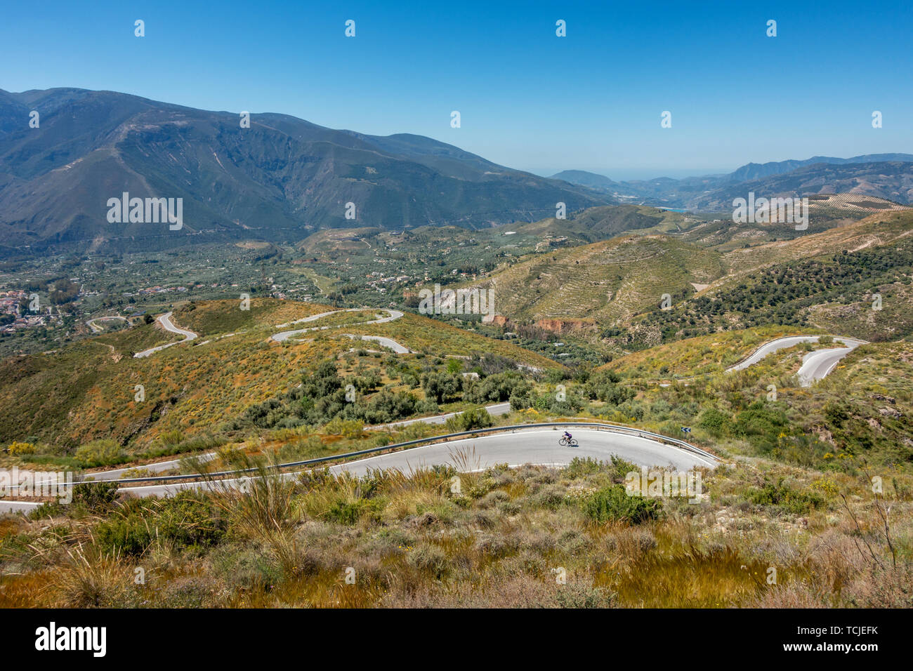 Cyclists ride down mountain road hi-res stock photography and images ...