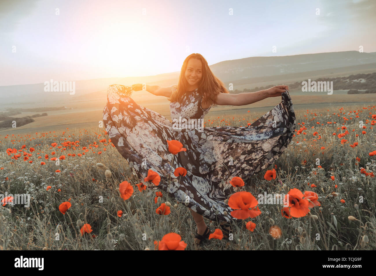 beautiful girl in a poppy field at sunset. concept of freedom Stock ...