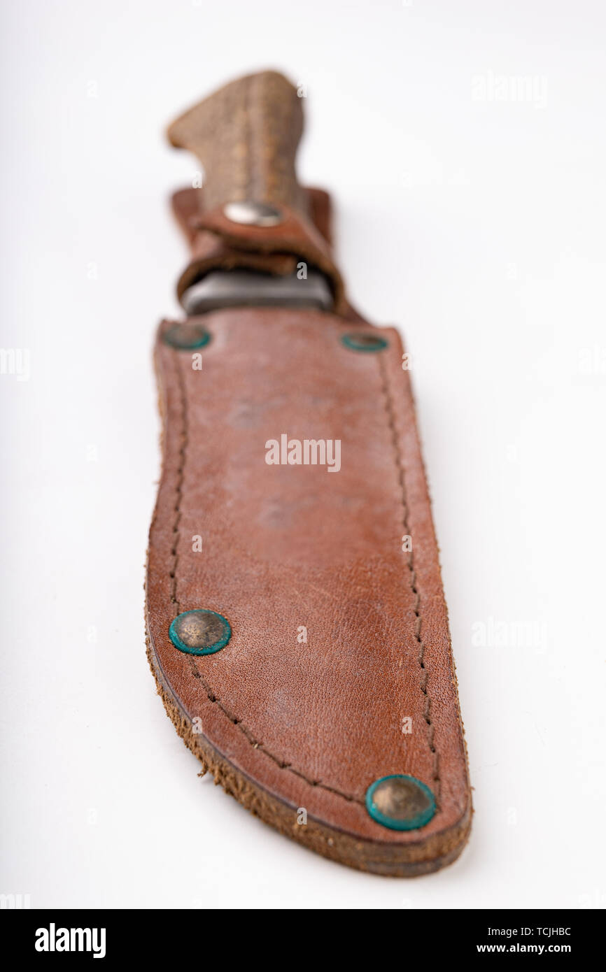An old little dirty hunting knife on a white table. Hunting accessories ...