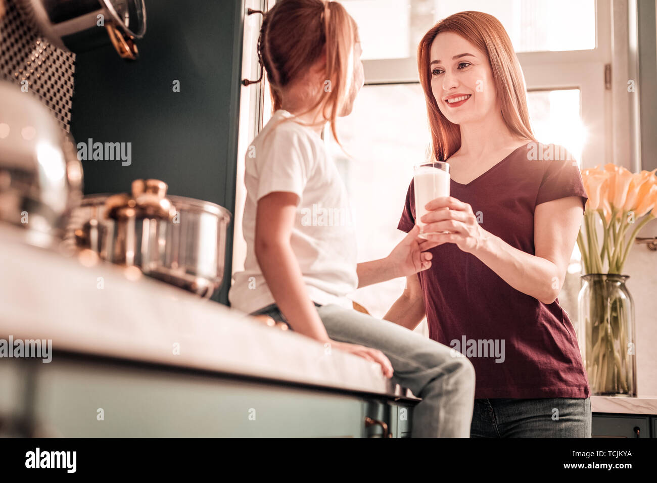 Pleased brunette woman giving milk to her child Stock Photo - Alamy